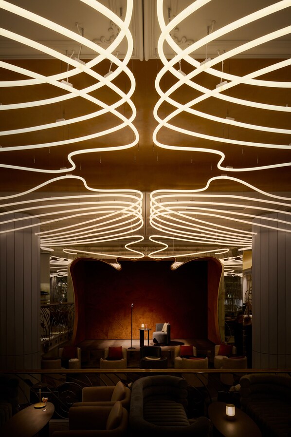 Decoração moderna com parede curva vermelha, área de estar e design de luminária no teto.