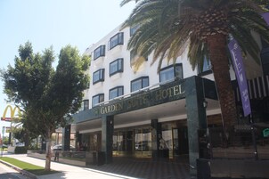 Um hotel com fachada moderna, grandes janelas e uma entrada imponente.