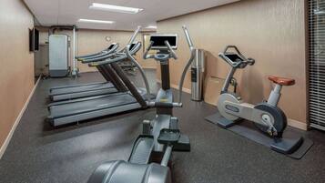Uma academia com esteiras, elípticos e bicicleta ergométrica.