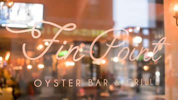 Interior de restaurante com uma placa que diz 'Fin Point Oyster Bar & Grille'.