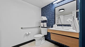 Uma casa de banho moderna com sanita, lavatório e porta-toalhas.