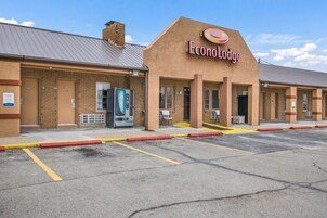 Um EconoLodge com fachada de tijolos, vários quartos e estacionamento.