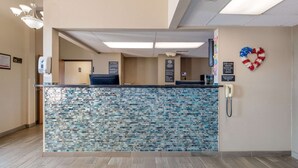 Uma área de recepção com balcão de mosaico, um telefone e uma decoração em formato de coração na parede.