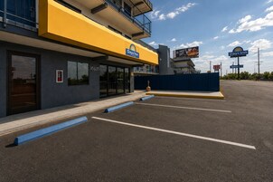 Um hotel Days Inn com toldo amarelo, um hidrante e céu claro.