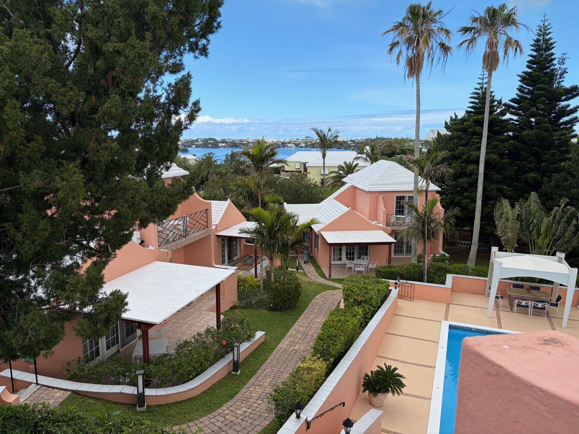 Uma área residencial com casas, piscina e vista para o oceano.