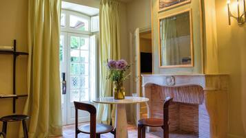 Um quarto com lareira, uma mesa com cadeiras e uma porta que dá para o exterior.