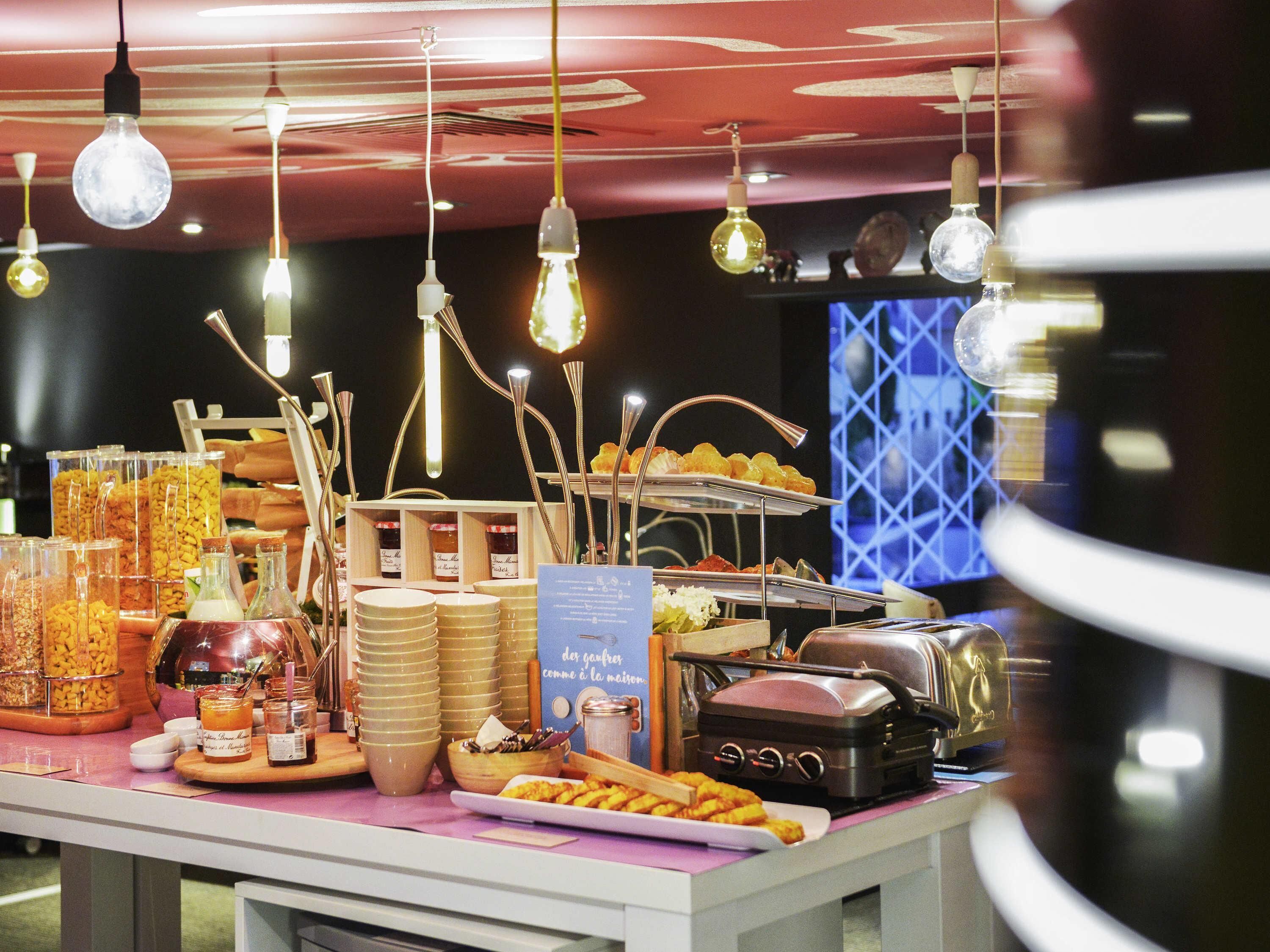 Disposição de buffet com diversos alimentos, dosadores de tempero e uma máquina de café.