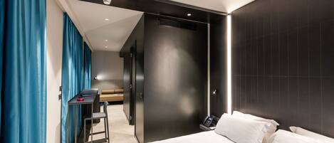 Quarto de hotel moderno com uma cama grande, uma mesa e uma cadeira.