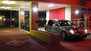 Um edifício moderno com um carro estacionado na frente.