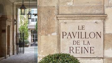 Uma placa de pedra com a inscrição 'LE PAVILLON DE LA REINE', indicando um pavilhão real.