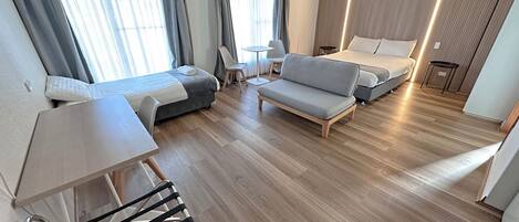 Quarto de hotel moderno com cama, sofá e uma pequena mesa.