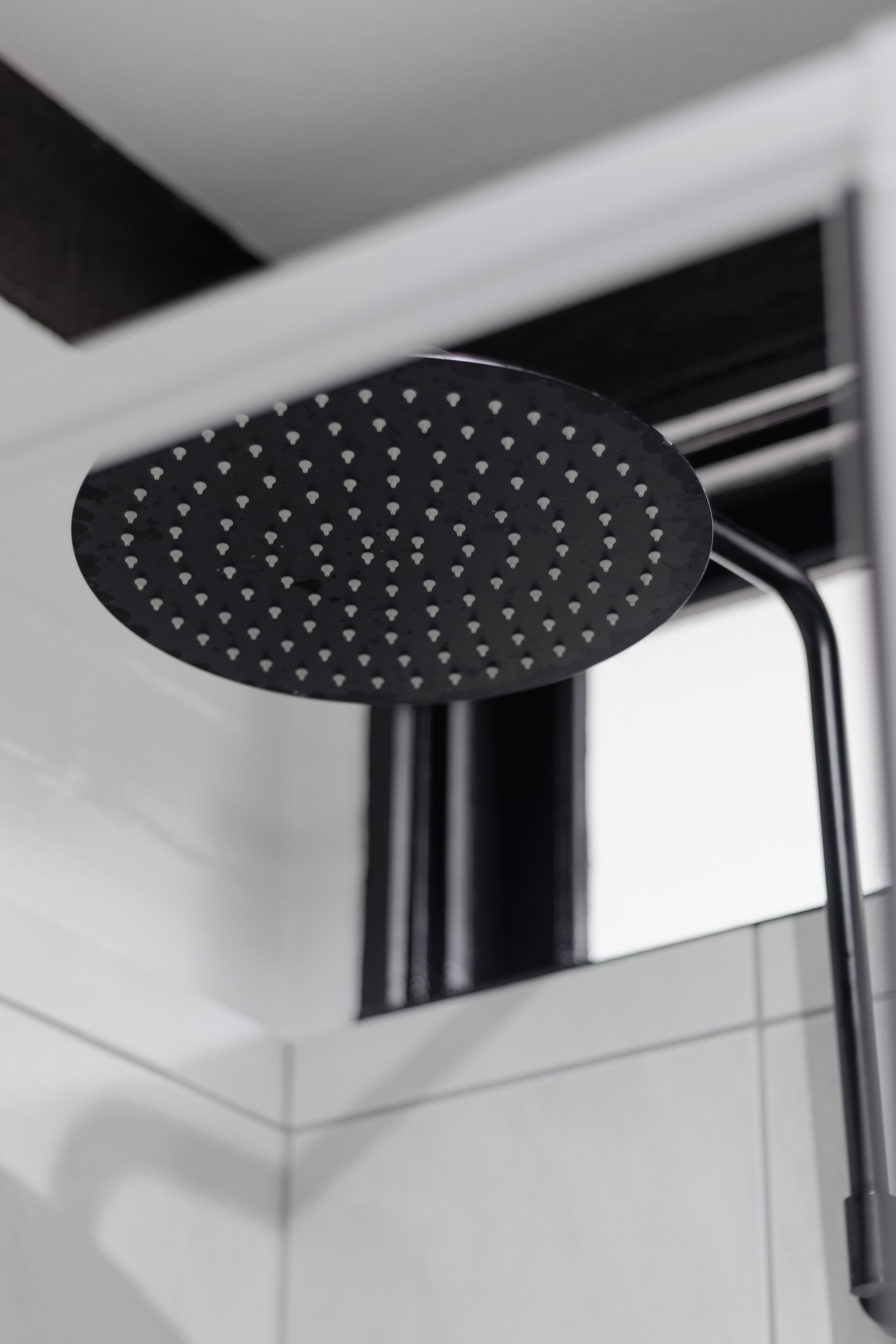 Um chuveiro moderno com design preto e perfurado.