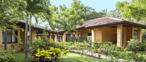 Um hotel com vários quartos, cada um com varanda e vista para o jardim.