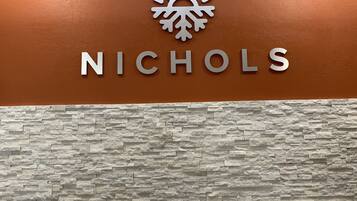 Uma parede com o nome "Nichols" e um logotipo semelhante a um sol.