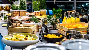 Buffet com diversos alimentos, incluindo frutas, legumes e uma variedade de pratos.