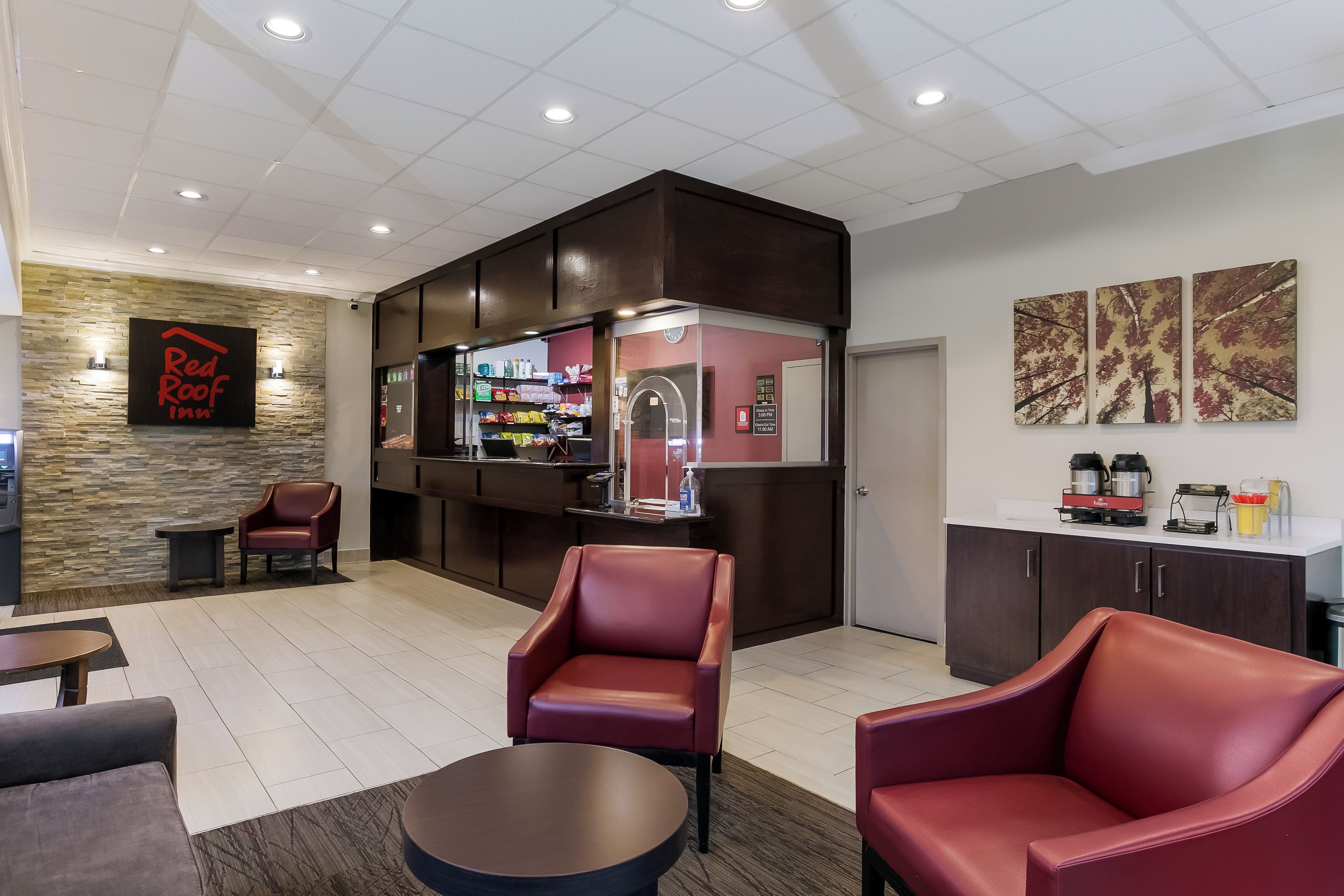 Lobby do Red Roof Inn com assentos de couro, balcão de check-in e estação de café.
