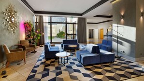 Um hall moderno com sofás, poltronas e uma mesa de centro.