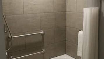 Um banheiro moderno com banheira, chuveiro e porta-toalhas.