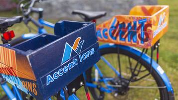 Uma bicicleta com uma caixa na parte de trás identificada com a inscrição 'Accent Inns'.