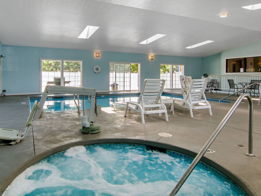 Piscina interna com várias espreguiçadeiras e sala de trocas.