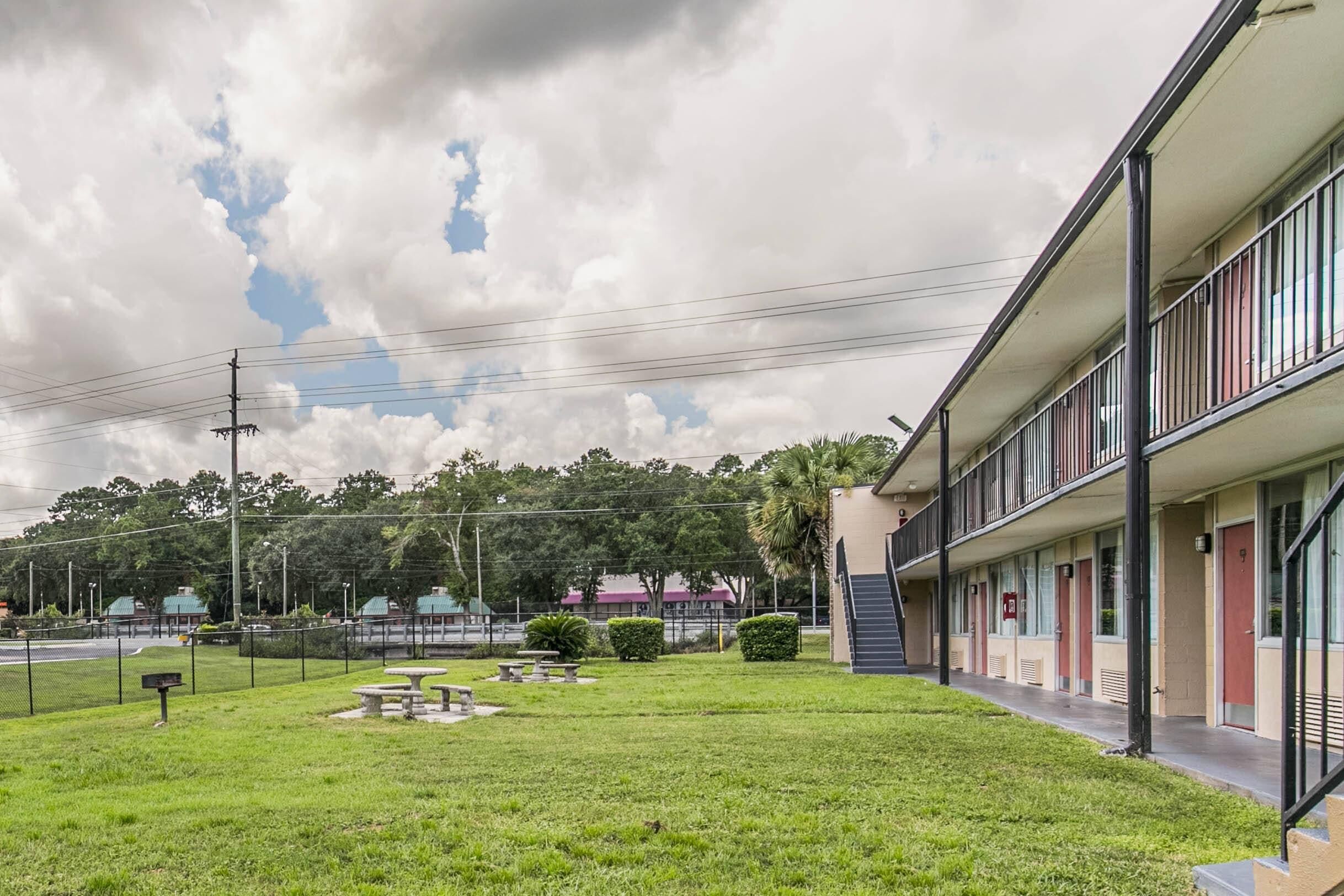 Um hotel com um pátio ajardinado, mobiliário para área externa e vista para os arredores.