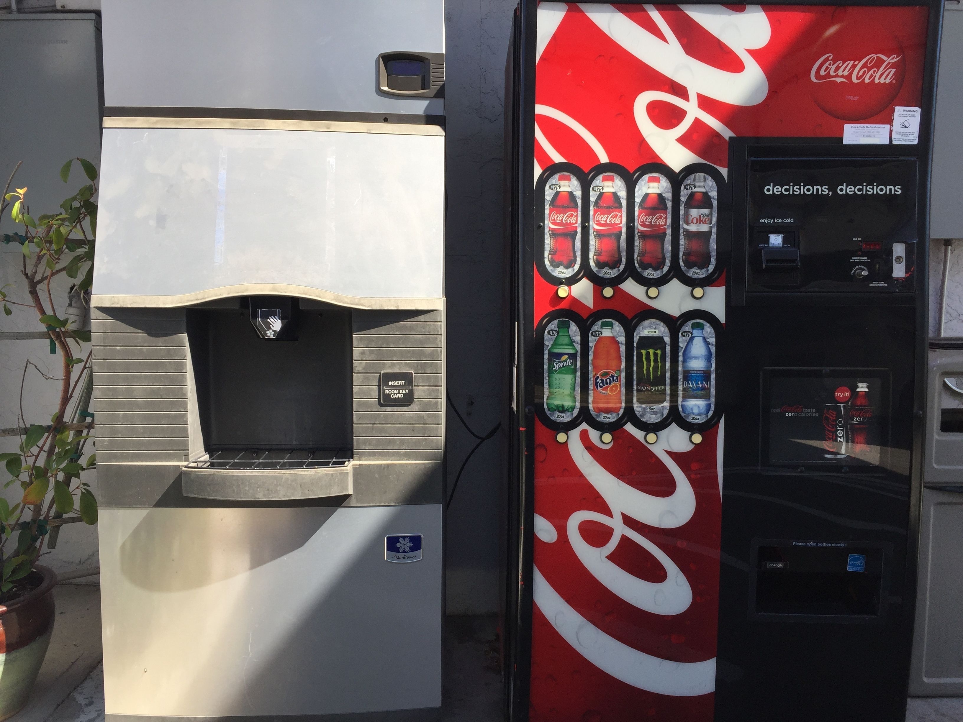 Máquina de vendas de Coca-Cola com entrada para cartão de quarto e dispensador de água.