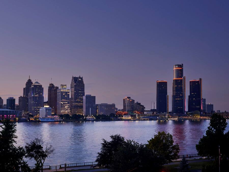 Horizonte urbano ao entardecer com edifícios iluminados ao longo da orla.