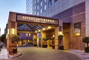 Entrada do hotel Intercontinental Buenos Aires com galeria coberta, vasos de plantas e céu claro.