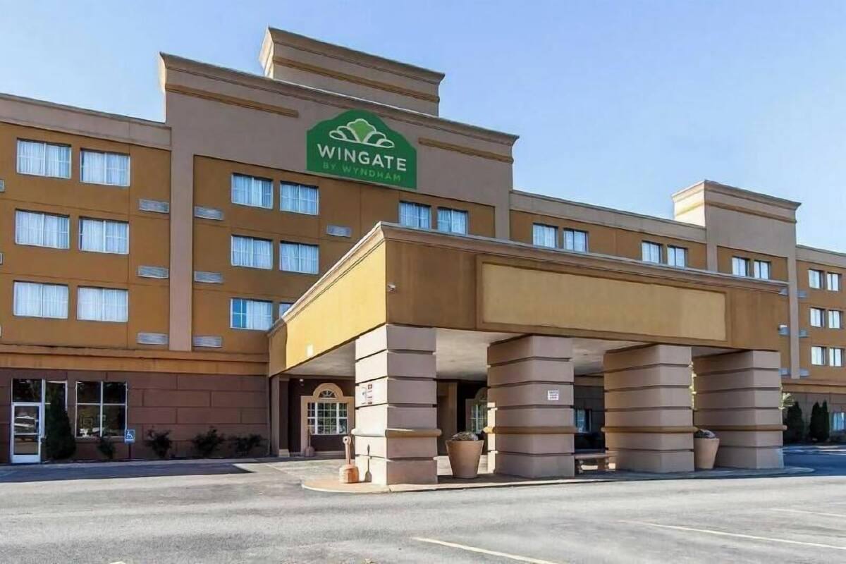Um hotel Wingate by Wyndham com design moderno, vários andares e uma entrada imponente.