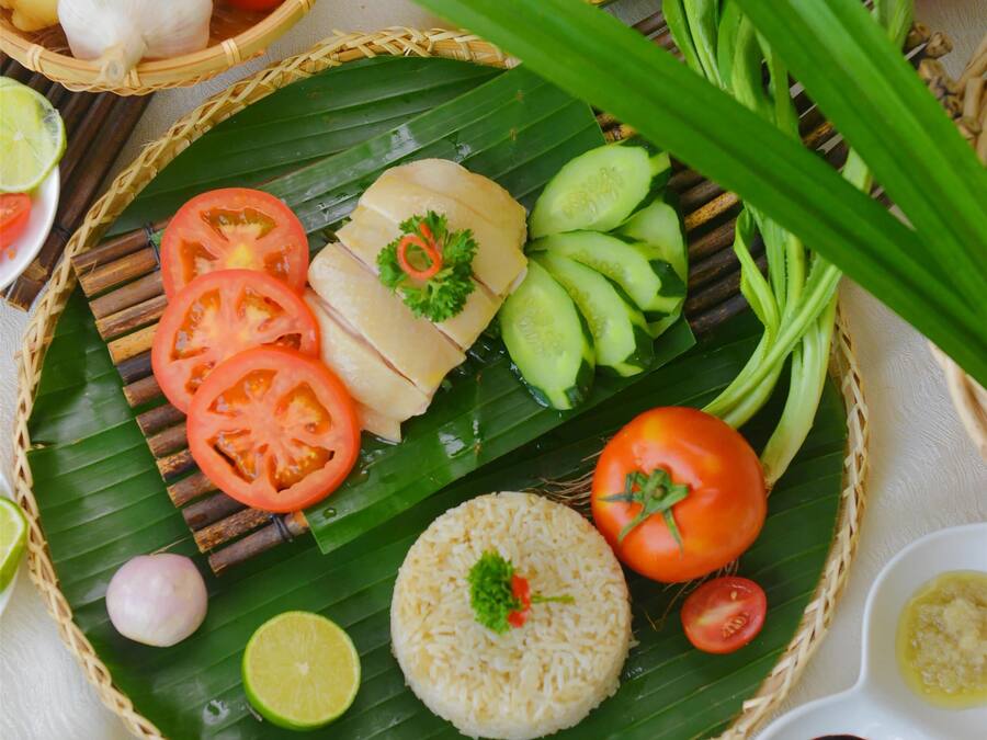 Diversos alimentos dispostos sobre uma mesa, incluindo tomates fatiados, pepinos e uma abacaxi.
