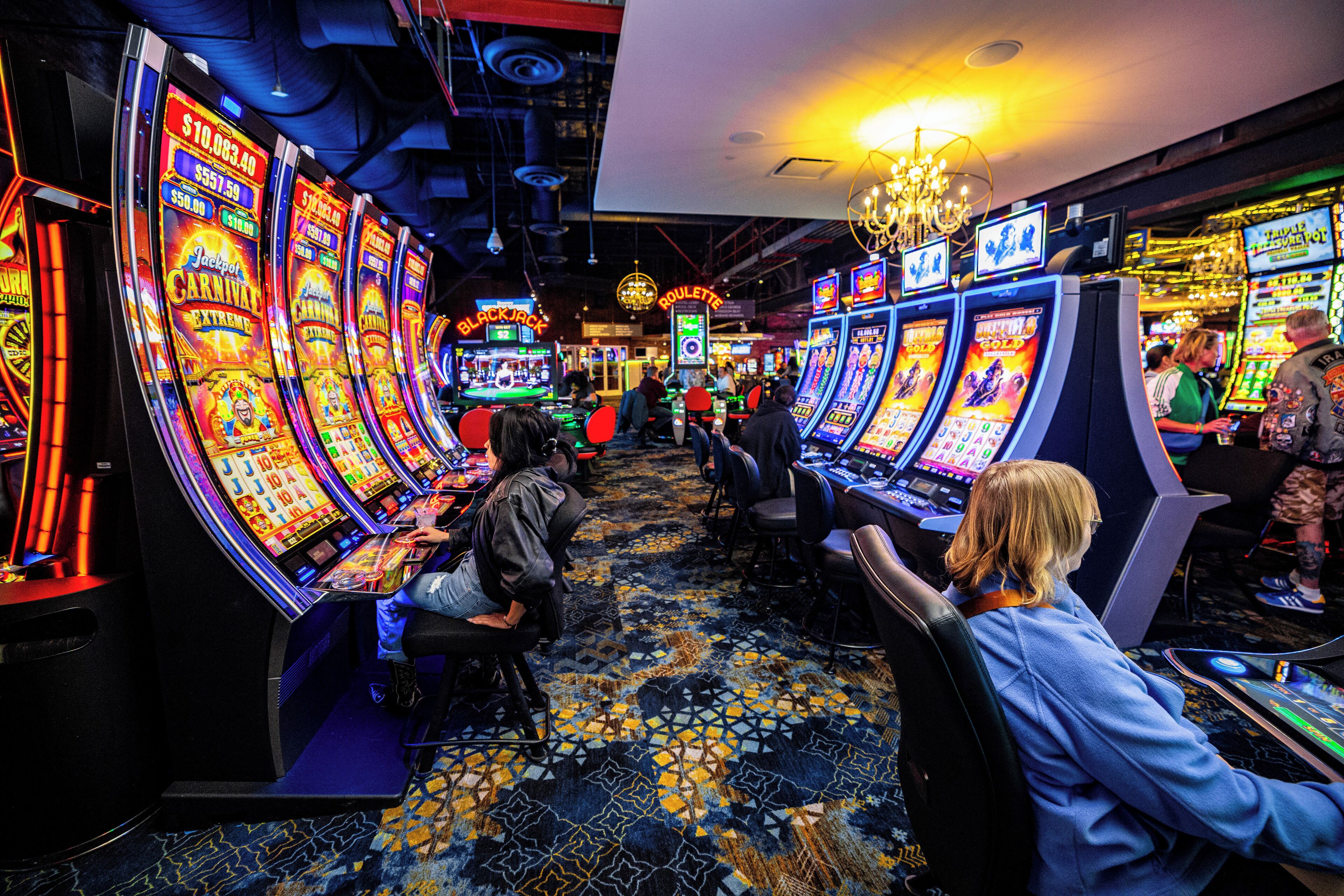 Um casino com várias máquinas de slot e um tapete estampado.