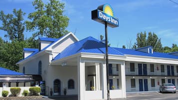 Um Days Inn com teto azul, um letreiro convidativo e um aviso de altura restrita.