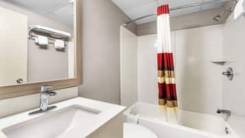 Casa de banho moderna com lavatório, sanita e banheira.