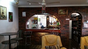 Uma área de bar com paredes de tijolo, um balcão e assentos.
