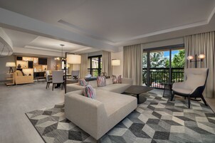 Quarto de hotel moderno com área de estar, espaço para refeições e varanda com vista.