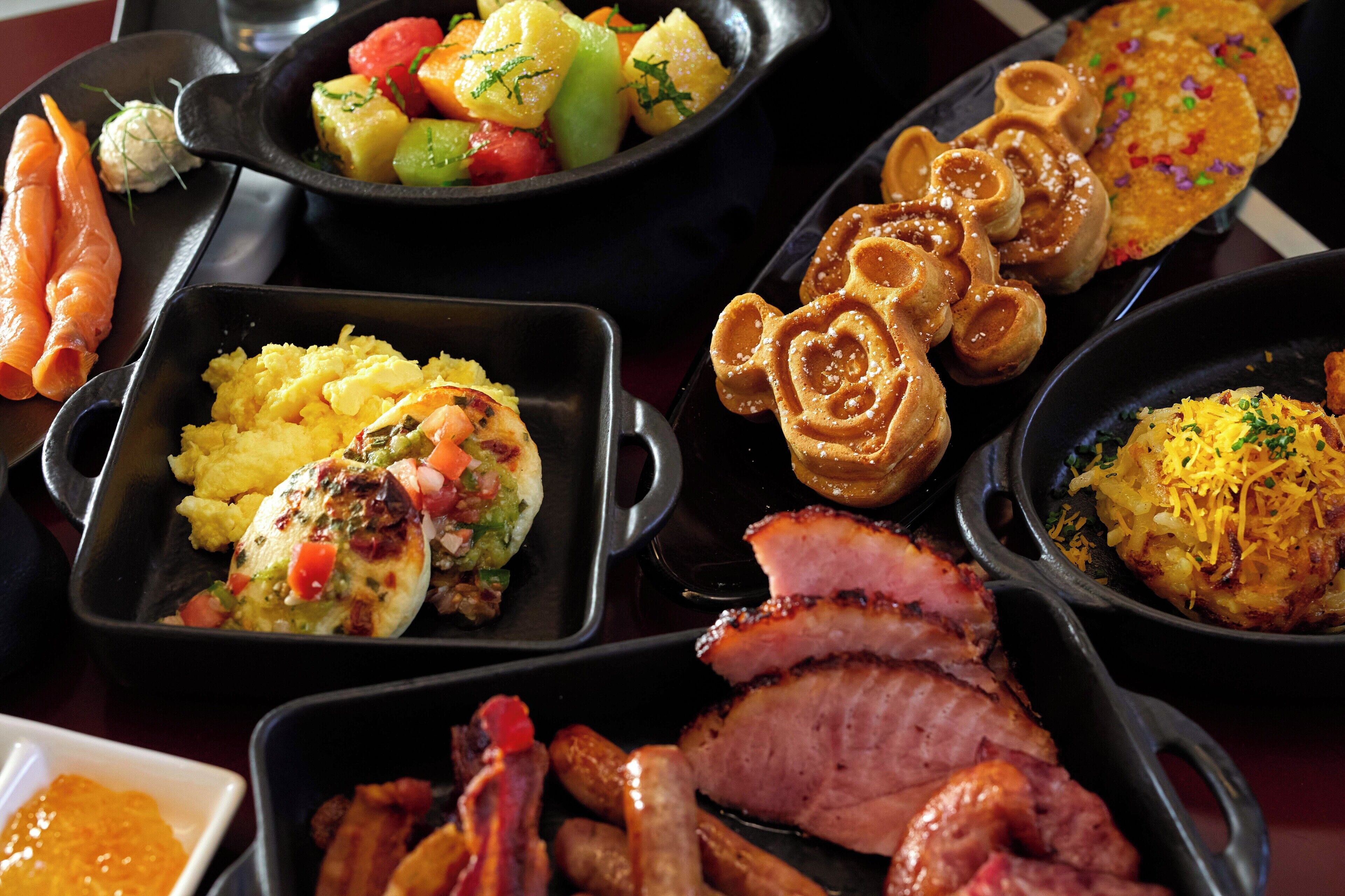 Diversos pratos, incluindo presunto, waffles e legumes.
