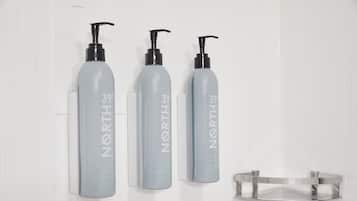 Três frascos de shampoo North numa parede branca.
