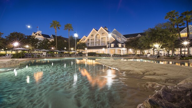 Resort com uma piscina grande, espreguiçadeiras e um edifício com várias varandas.