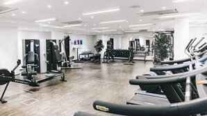 Uma academia moderna com diversos equipamentos de exercício, incluindo esteiras, aparelhos de musculação e pesos livres.