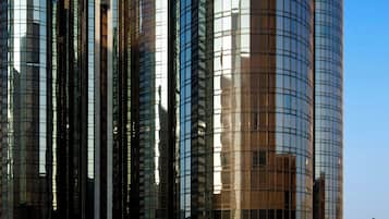 Um edifício moderno com fachadas de vidro cilíndricas e uma estrutura central de concreto.