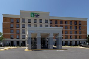 Edifício do Holiday Inn Express & Suites com fachada de tijolos e entrada numerada.