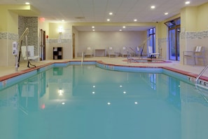 Uma piscina interior com água cristalina, linhas de profundidade marcadas e várias pistas.