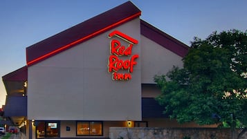 Edifício Red Roof Inn com um telhado vermelho destacado e um letreiro neon.