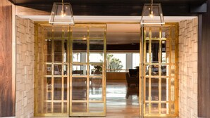 Um hall amplo com grandes portas de vidro e um lustre moderno.