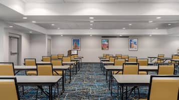 Uma sala de conferências com mesas e cadeiras dispostas para reuniões.