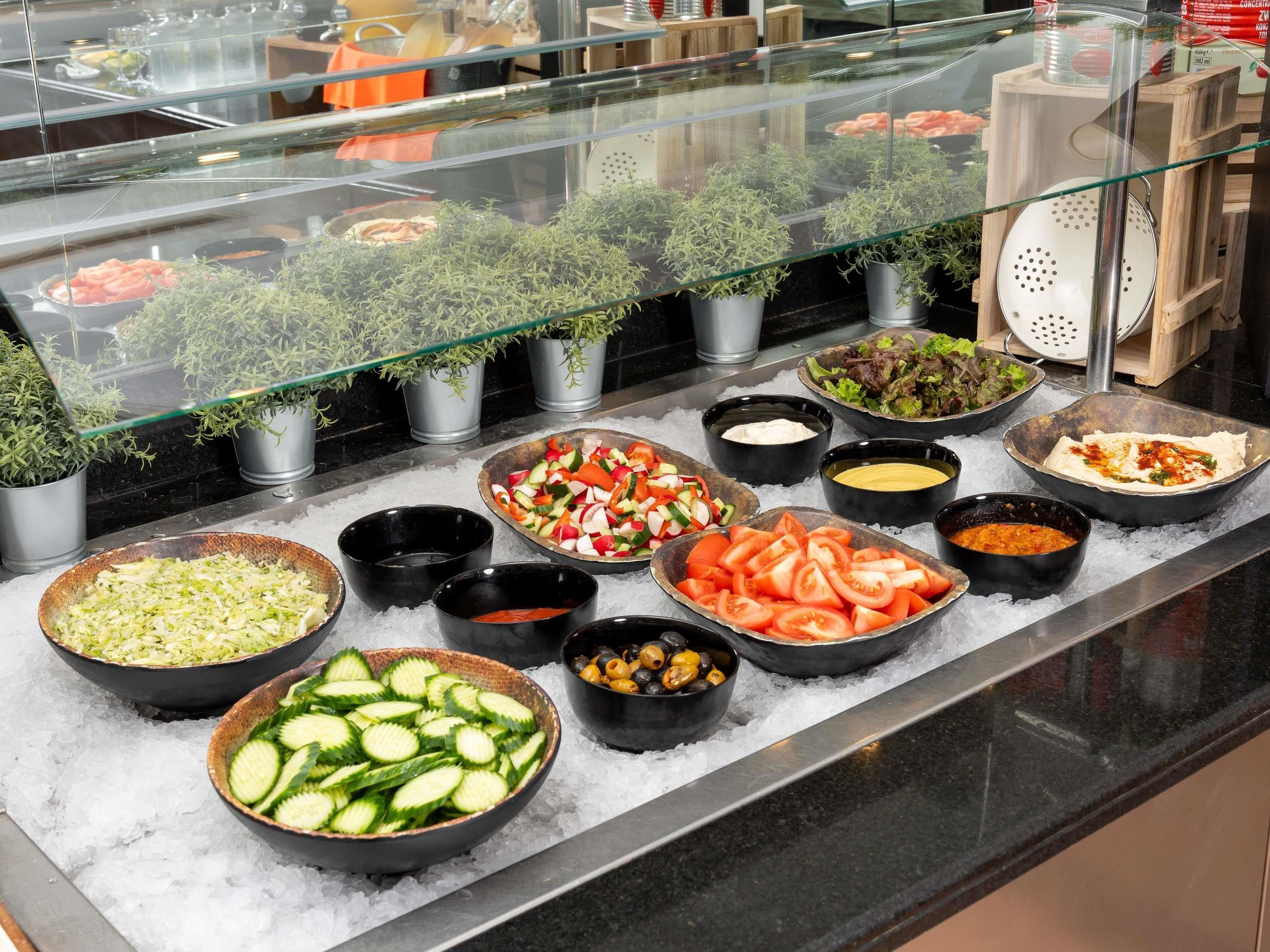 Buffet com diversos alimentos e acompanhamentos sobre gelo.