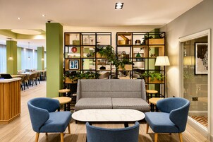 Uma área de estar moderna com um sofá, duas poltronas, uma mesa de centro e uma estante decorativa.