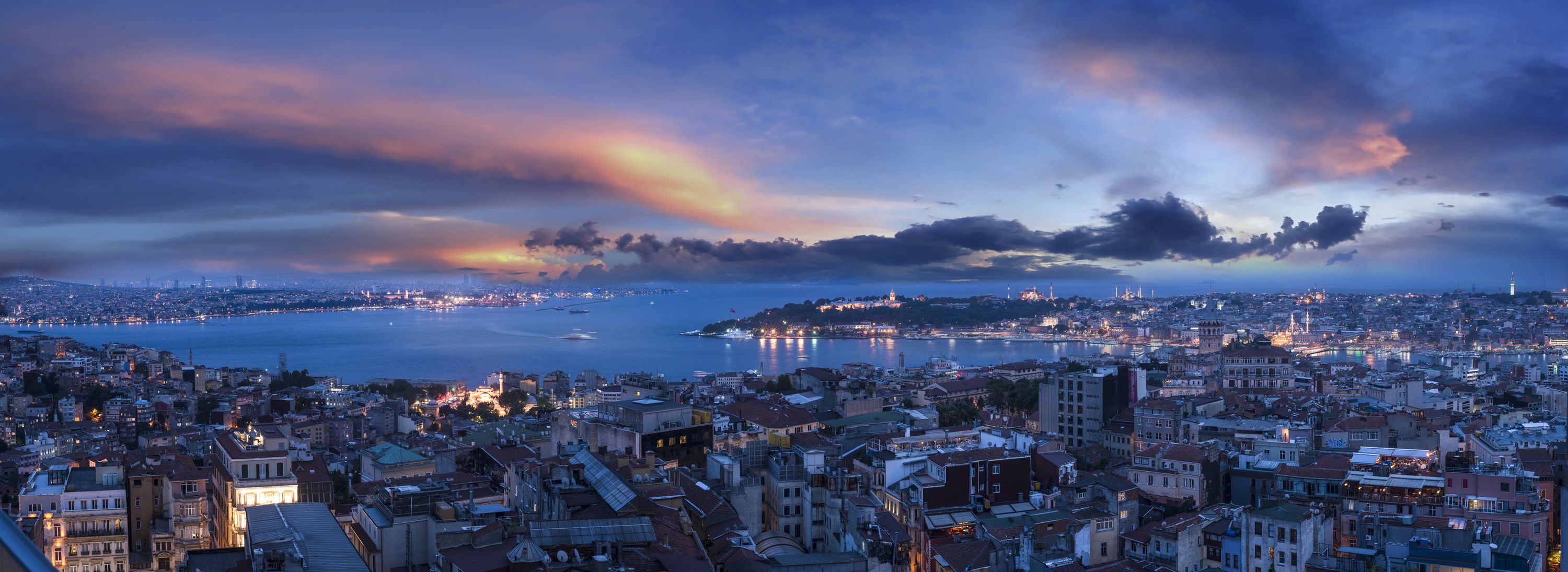 Paisagem urbana com vista para o mar e uma fortaleza histórica.