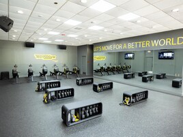 Uma academia com equipamentos de ginástica, espelhos e frases motivacionais na parede.