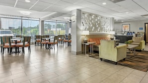 Um hall amplo com área de estar, balcão de recepção e vista para o exterior.